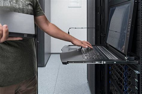 Data Center Engineer Types On Supercomputer With Male System Admin For