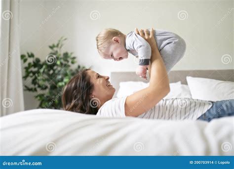 Madre E Hijo En Una Cama Blanca Jugando En Un Dormitorio Soleado Foto De Archivo Imagen De