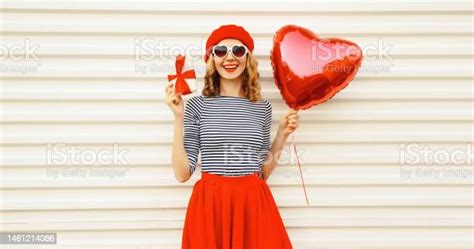 흰색 배경에 베레모와 치마를 입은 빨간 하트 모양의 풍선과 선물 상자를 가진 행복한 미소 짓는 여자의 초상화 25 29세에 대한 스톡 사진 및 기타 이미지 Istock