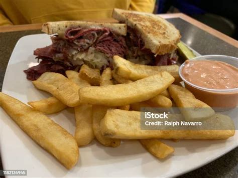 맛있는 클리블랜드 스타일의 르우벤 샌드위치 호밀 빵 스위스 치즈 루마니아 파스트라미 소금에 절인 양배추 측면에 러시아 드레싱 펍 프라이와 바삭바삭한 딜 피클이 함께 나옵니다