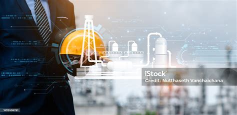 대형 정유 공장 내부에서 작업을 감독하는 엔지니어이자 건축가인 그는 손에 노란색 헬멧을 들고 있습니다 건축가는 정유 공장 건축가