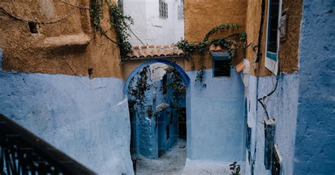 파란 벽과 연철 난간이 있는 좁은 골목길 사진 Unsplash의 보도 이미지