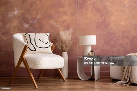 복사 공간 흰색 안락 의자 커피 테이블 램프 말린 꽃병이있는 꽃병 및 개인 액세서리가있는 거실 인테리어의 인테리어 디자인 가정