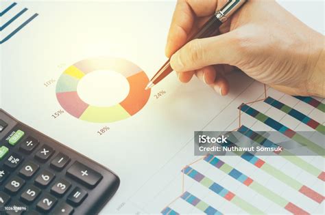 사무실 책상 금융 사업 예산 계획 또는 분석 개념에 계산기와 원형 차트와 그래프 정보 보고서를 검토 하는 펜을 들고 여성 손
