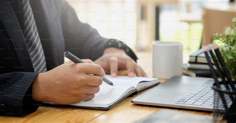 사무실에서 책상에 메모를 쓰는 사업가의 손의 자른 이미지 사진 Unsplash의 기술 이미지