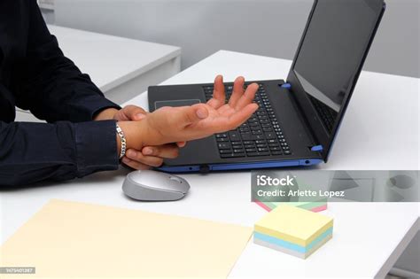 손목 터널 증후군으로 인해 손목의 통증 따끔 거림 무감각 및 약점으로 고통받는 성인 라틴 남성 노트북과 마우스로 사무실에서 일하는 동안 노트북에 대한 스톡 사진 및 기타