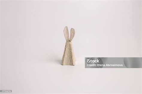 빈 달걀 상자 상자 또는 재활용 종이로 만든 토끼를 닮은 간단한 물건 긴 귀 꼿꼿한 자세 밝은 배경에 배치되어 미니멀하고 창의적인 디자인을 선보입니다 0명에 대한 스톡 사진