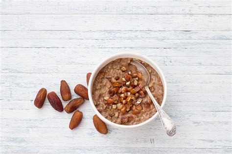 흰 그릇에 맛 있는 오트밀 대추 과일과 코코아 밝은 파란색 배경에 건강 한 아침 식사 갈색에 대한 스톡 사진 및 기타 이미지 갈색 건강한 식생활 곡초류 Istock