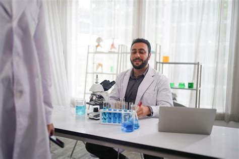 Premium Photo Lab Worker Using Magnifying Glass On Microscope