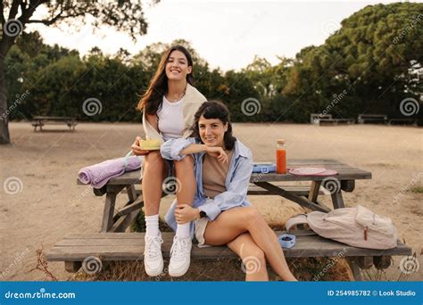 Cute Young Caucasian Girls Smiling Looking At Camera Sitting On Picnic