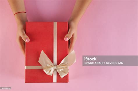 고립 된 분홍색 배경에 선물 상자 직사각형 선물 상자 여자의 손이 상자를 잡았다 계절에 대한 스톡 사진 및 기타 이미지 계절