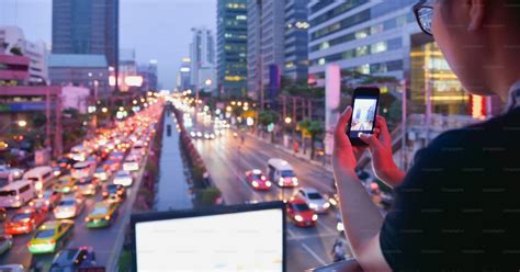 도시의 교통 체증과 건물에서 스마트폰으로 사진을 찍는 아시아 여성 공간을 복사합니다 사진 Unsplash의 무선 기술 이미지