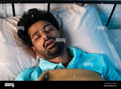 Close Up Shot Of Man Sleeping By Snoring With Mouth Open During Night Concept Of Relaxation