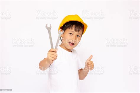 딱딱한 모자를 쓴 귀여운 소년이 렌치와 망치를 가진 아이의 손에 오른쪽을 바라본다 개인 보호 장비 및 특수 공구 사용의 중요성의 개념 8 9 살에 대한 스톡 사진 및 기타
