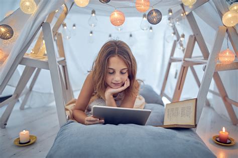 거실 안에 있는 집에서 만든 텐트 아래에서 태블릿을 사용하는 10세 소녀 태블릿에 대한 스톡 사진 및 기타 이미지 태블릿