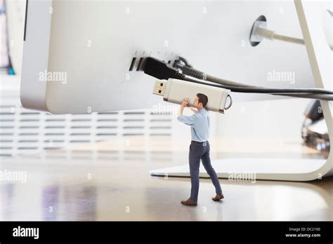 Businessman Holding Large USB Stick Next To Oversized Computer Monitor Stock Photo Alamy