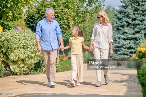 귀여운 장발 소녀와 함께 걷는 중년 남녀 가족에 대한 스톡 사진 및 기타 이미지 가족 걷기 3 명 Istock