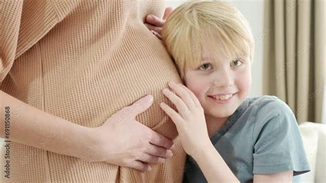 A Schoolboy Boy Hugging And Listening Belly Of His Pregnant Mother Pregnant Mother And Her