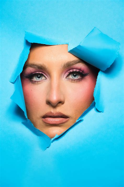 A Womans Face Is Seen Through A Hole In Blue Paper Photo Free Blue Image On Unsplash