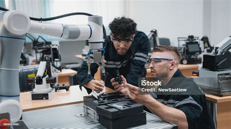 Student Engineer Assembling Robotic Arm With Computer In Technology