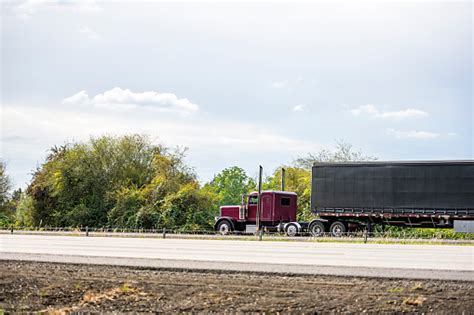 분할 된 고속도로 도로에서 실행 검은 색 덮인 세미 트레일러에서화물을 수송 수직 크롬 파이프 와 부르고뉴 고전적인 큰 장비 세련된 세미 트럭 0명에 대한 스톡 사진 및 기타