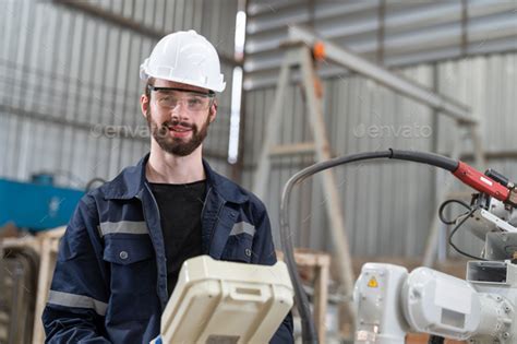 Male Automation Engineer Using Remote Controller Control Robot Arm