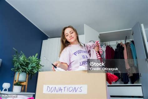 자선 상점에 기부하기 위해 옷장에서 엄선 된 옷을 입는 여성 정리 옷 정리 및 청소 재사용 중고 개념 의식있는 소비자 지속 가능한 라이프 스타일 붙박이장에 대한 스톡 사진