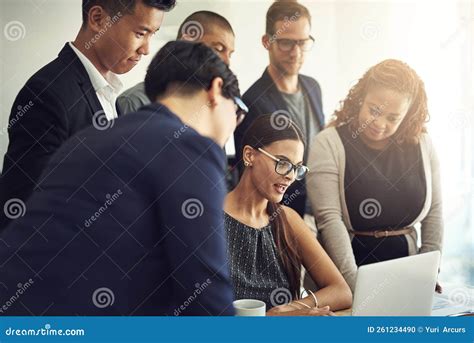 Evaluating The Pros And The Cons A Group Of Coworkers Discussing Something On A Laptop During A