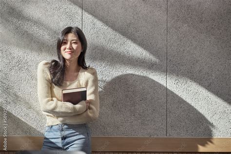 아시아 한국의 빛이 들어오는 대학교 강의실 벽에 기대어 있는 젊은 여자 대학생 모델 Stock 사진 Adobe Stock