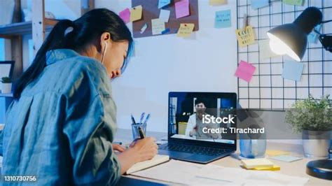 랩톱을 사용하는 아시아 사업가가 거실에서 화상 통화 회의에서 계획에 대해 동료들과 이야기합니다 2명에 대한 스톡 사진 및 기타