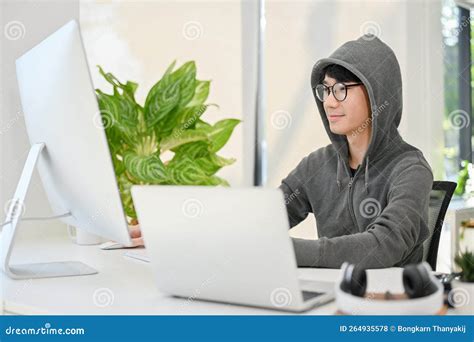 Nerd Young Asian Male Website Developer Or Programmer Focusing On His Task On Computer Stock