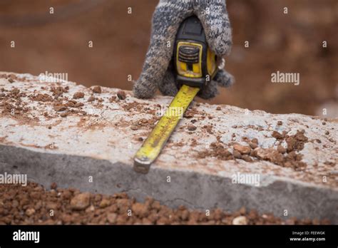 Worker Measuring Concrete At Construction Site With Tape Measure Stock Photo Alamy