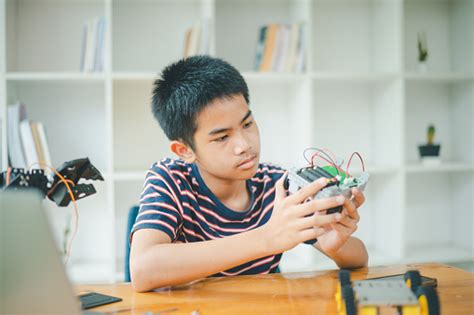 기술 로봇의 작업을 배우고 공부하는 아시아 소년홈스쿨과 기술 프로젝트를 위한 과학 어린 시절 아이들 취미 여가 라이프 스타일 사람들 장난감 로봇 공학 기술 12 13세에