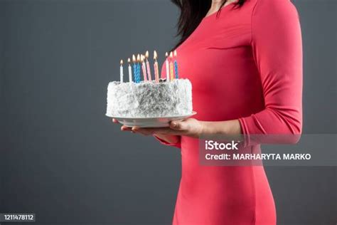 분홍색 드레스를 입은 한 소녀가 불타는 촛불을 들고 케이크를 손에 들고 클로즈업합니다 생일 축하 파티 기념일입니다 공간을 복사합니다 귀여운에 대한 스톡 사진 및 기타 이미지