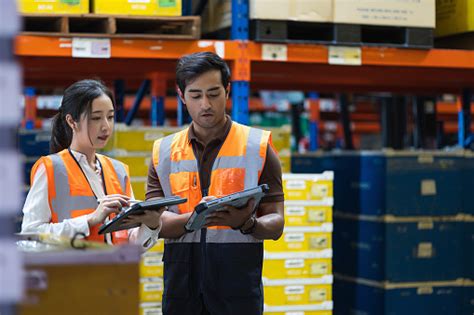 창고 작업자와 관리자는 상품이 있는 선반으로 가득 찬 소매 창고에서 디지털 태블릿 컴퓨터를 사용하여 재고와 재고를 확인합니다