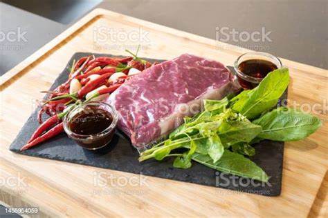 가까이서 생 쇠고기 허브 재료 바질 마늘 칠리 소스는 태국 음식 메뉴 볶음 쇠고기 바질을 요리하기 위해 검은 슬레이트 접시에 준비됩니다 0명에 대한 스톡 사진 및 기타