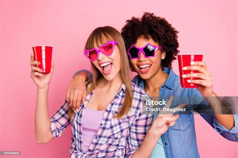 두 사람의 클로즈업 초상화 핑크 파스텔 배경 위에 고립 된 V 기호를 보여주는 캐주얼 체크 무늬 셔츠에 좋은 귀여운 사랑 스러운