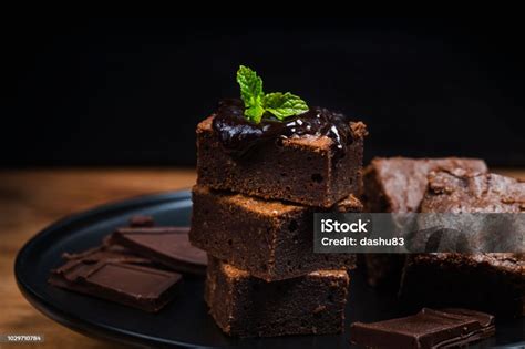 수 제 다크 초콜릿 브라 우 니 아몬드 슬라이스와 민트와 토 핑 나무 테이블 복사 공간에 쌓입니다 맛 있는 쓰라린 달콤한 그리고 퍼지입니다 브라 우 니 초콜렛 케이크의 한