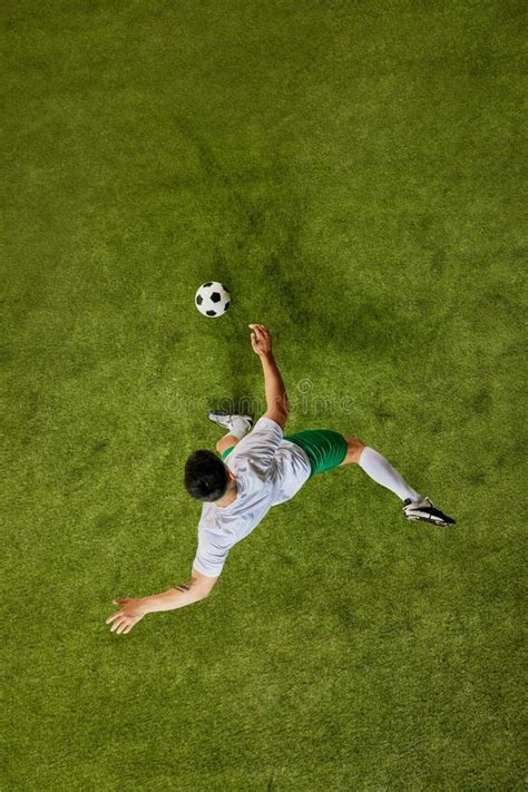 Top Down Perspective Of Footballer Executing Powerful Kick Showcasing Their Athletic Prowess On