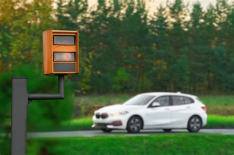 Premium Photo A Yellow Speed Camera Flashes As It Detects A Speeding Car On A Highway Using