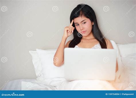 Beautiful And Woman Using Laptop Computer On Bed Before Fall Asleep
