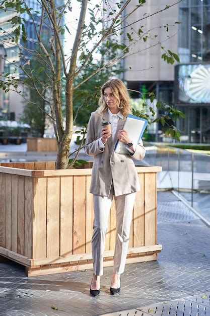 Free Photo Energized Businesswoman Drinks Coffee Gets Takeaway On Lunch Near Office Building