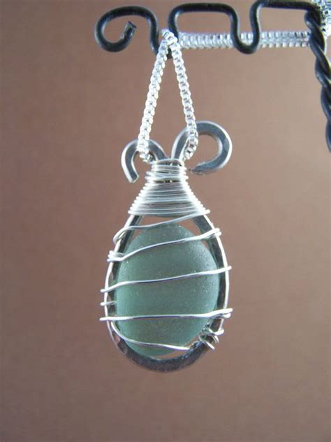A Wire Wrapped Glass Pendant Hanging From A Hook
