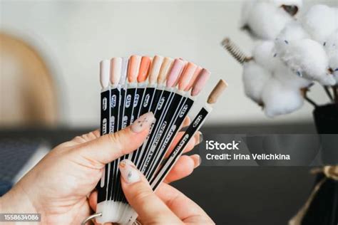 여러 가지 빛깔의 매니큐어 샘플 팔레트 뷰티 살롱의 전문 마스터 매니큐어사 매니큐어 서비스 손 치료 손톱 시술 손가락 문신 큐티클 오일 젤 Uv 램프 장갑 건강관리와 의술에