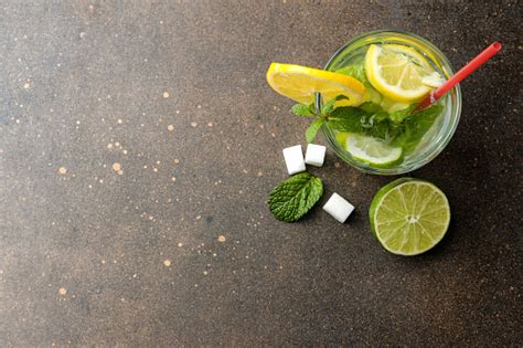 라임 민트 레몬이 있는 유리 텀블러와 어두운 콘크리트 배경에서 모히토 칵테일을 즐기실 수 있습니다 모히토를 만드십시오 맨 위 보기입니다 무료 장소 0명에 대한 스톡 사진 및