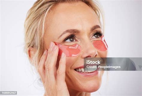 안대 얼굴 피부과에서 여성과 미소 뷰티와 스킨케어를 스튜디오 배경에서 행복한 사람과 함께한다 건강한 피부 콜라겐 마스크로 빛나는 여성의 생각 셀프 케어가 있는 화장품 40