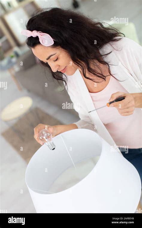 Woman Changing Light Bulb In Lamp At Home Stock Photo Alamy