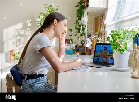 Adolescent Teen Girl Looking At Laptop Screen Talking With Teacher