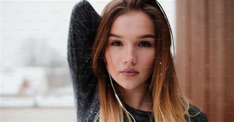 이어폰을 낀 어린 소녀 또는 여성의 초상화는 테라스에서 야외에서 스트레칭을 하고 있습니다 공간을 복사합니다 사진 Unsplash의 사진술 이미지