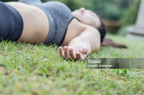 아름 다운 매력적인 아시아 여자 연습 요가 시체 자세 또는 Savasana 포즈 너무 긴장을 느끼는 명상과 편안 하 게 의료 개념 요가 대 한 녹색 잔디에 누워 명상하기에